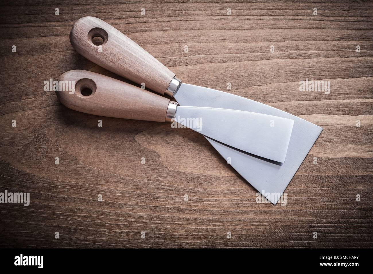 two steel putty spattles with wooden handles Stock Photo - Alamy