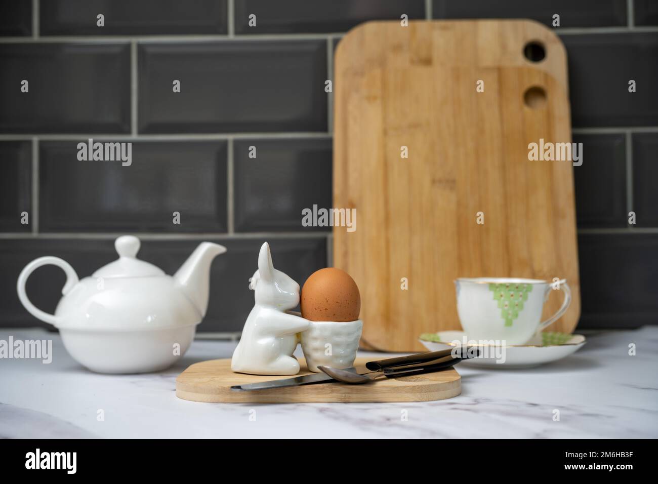 selected focus on the pottery rabbit and basket egg cup with boiled egg ...
