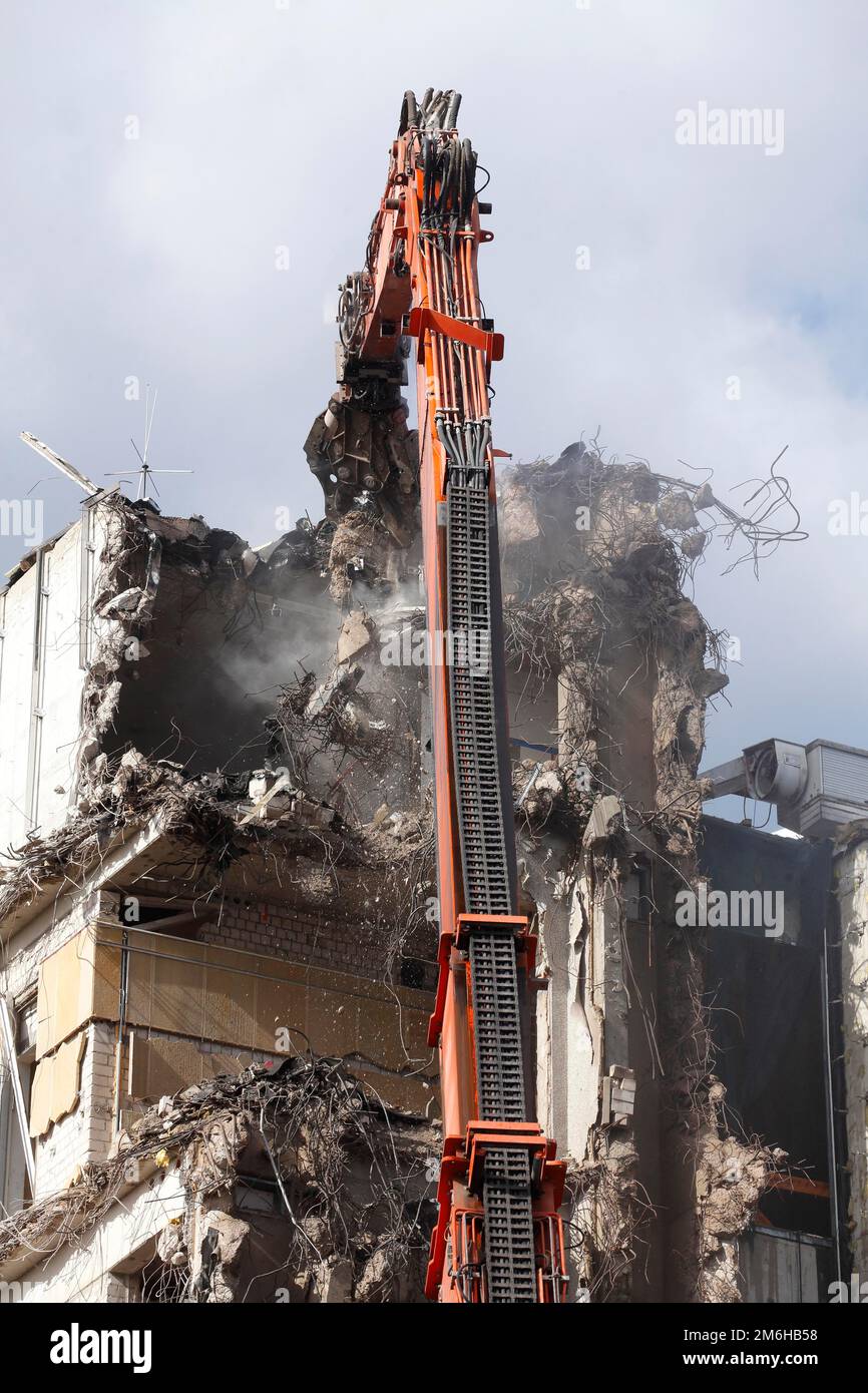 Demolition excavator and rubble of a demolished house, former office ...