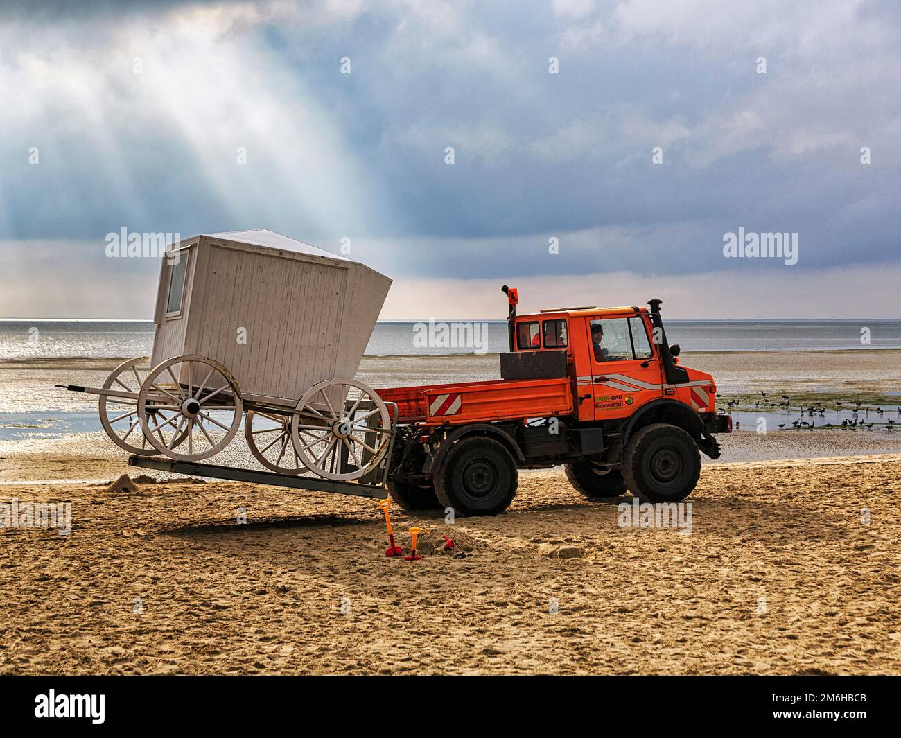 Historic beach wagon, transport in autumn, sunbeams in cloudy sky ...