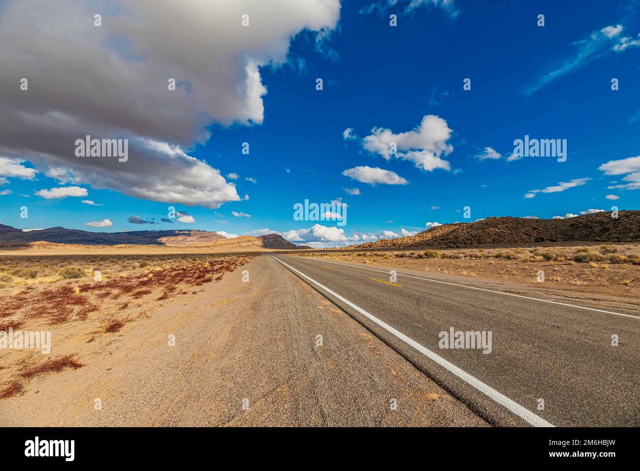 A Dramatic Clouds 2-lane highway in Nevada with Desert Mountains in the ...