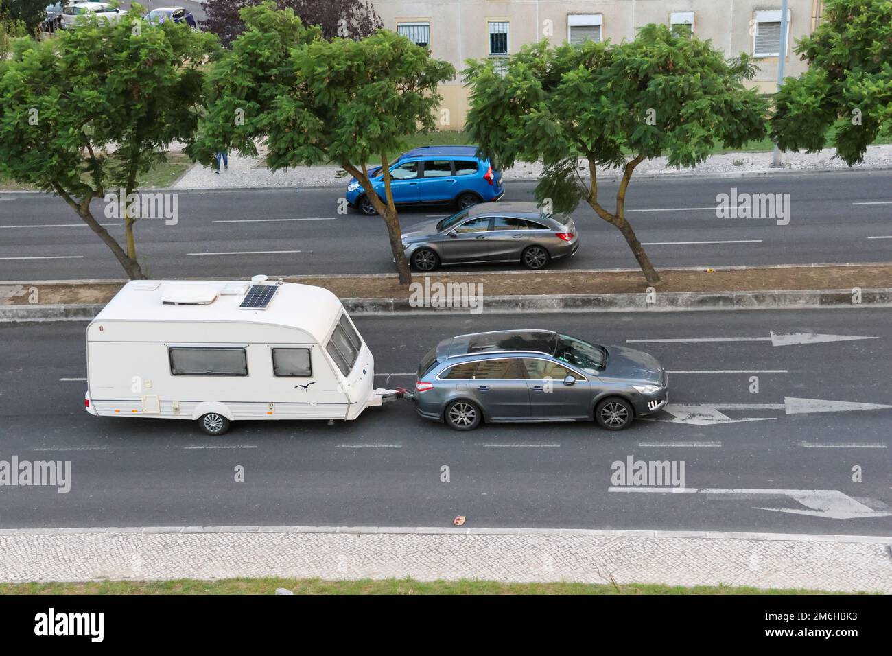 An aerial view of vehicles on the road including a car towing a trailer ...