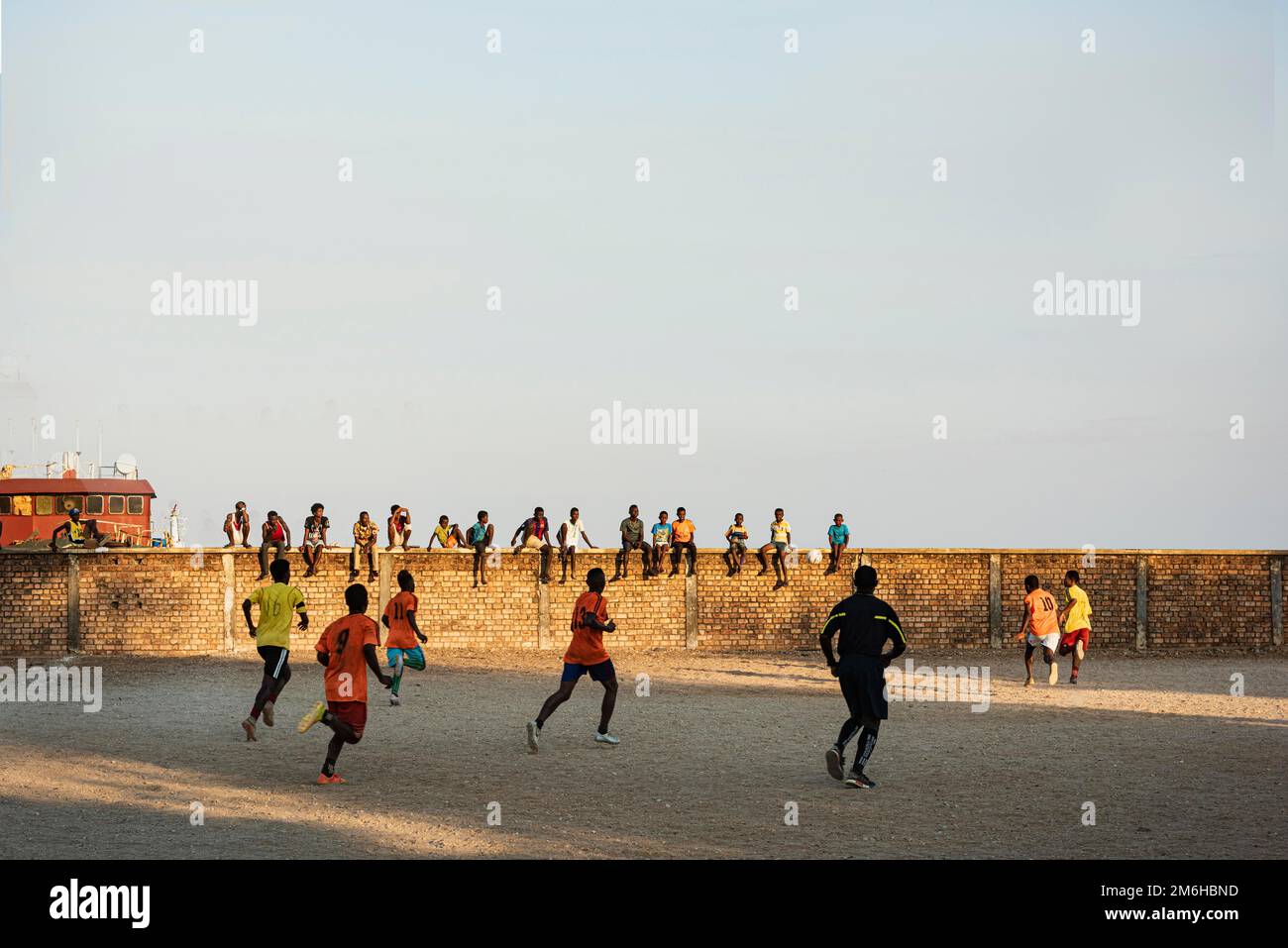 Boys, football pitch, youths playing football, wall with spectators ...