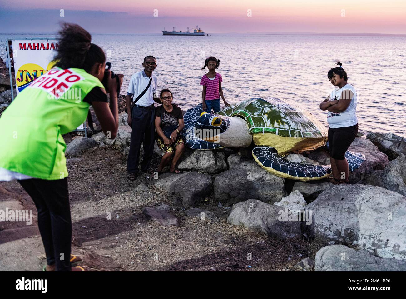 Photographer, photographs family with artificial turtle, dummy, papier ...