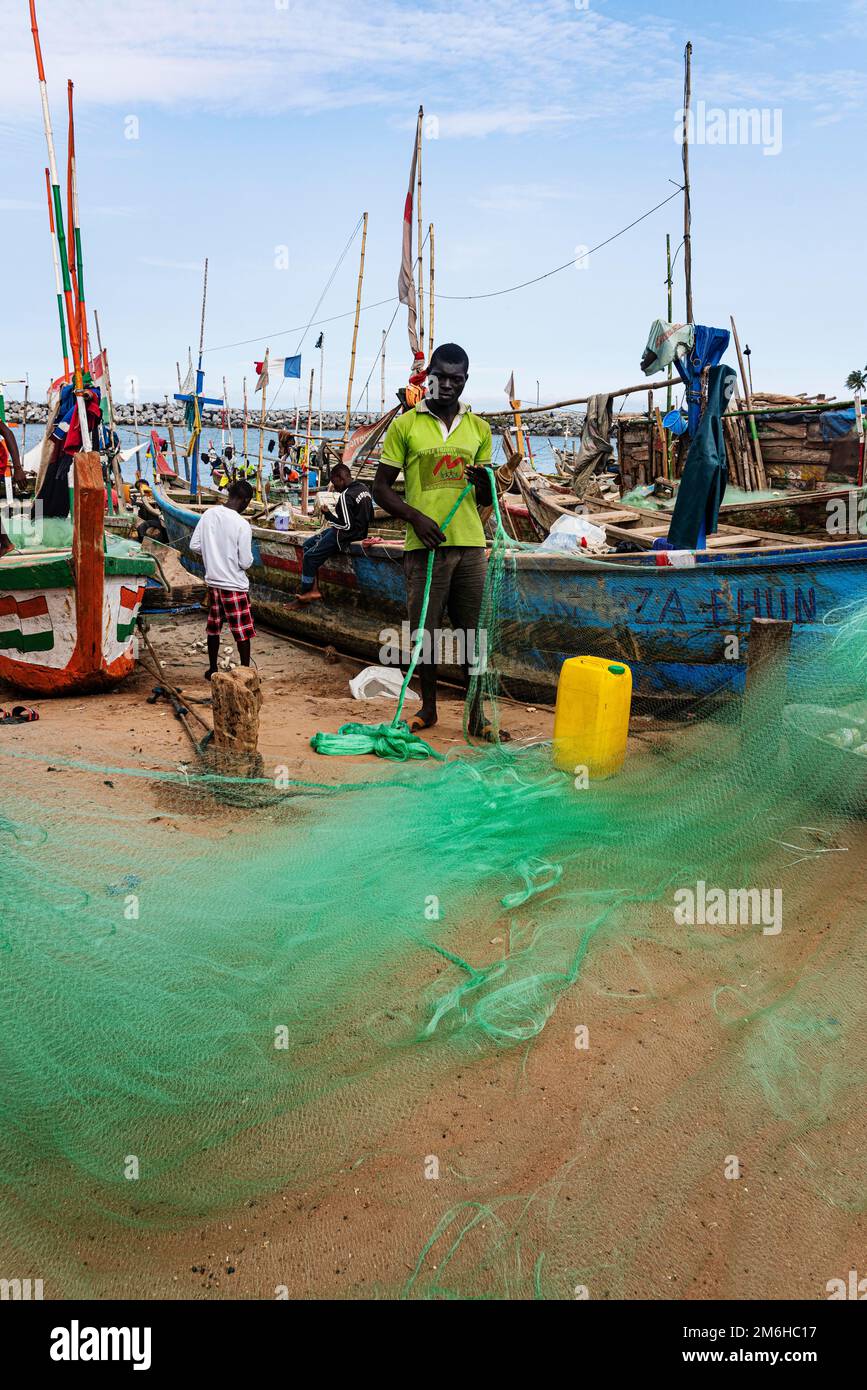 Fishermen mending nets, fishing boats, pirogues, beach, Elmina, Gulf of ...