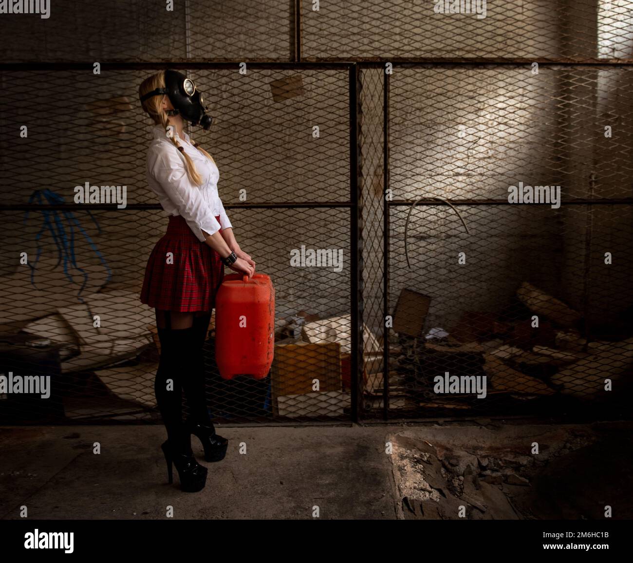 Woman with gas face protective mask holding axe in an underground ...