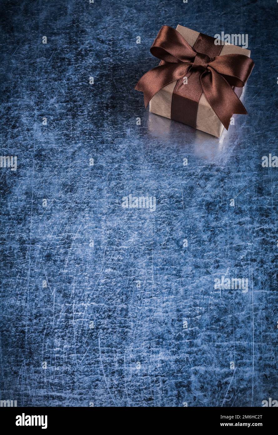 Wrapped gift box on scratched metallic background holidays concept ...