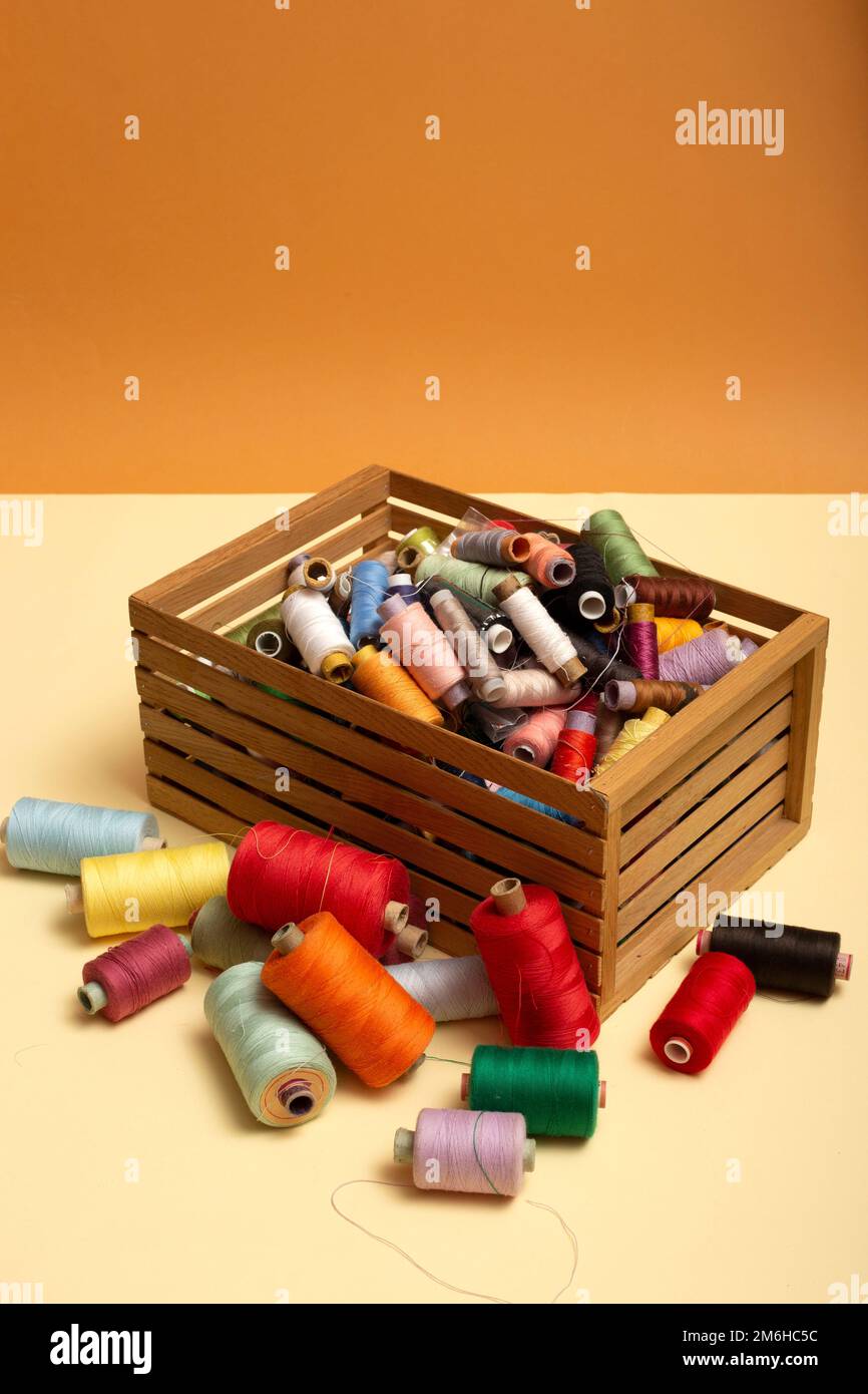 A box with multi colored coins of different threads on a colored ...