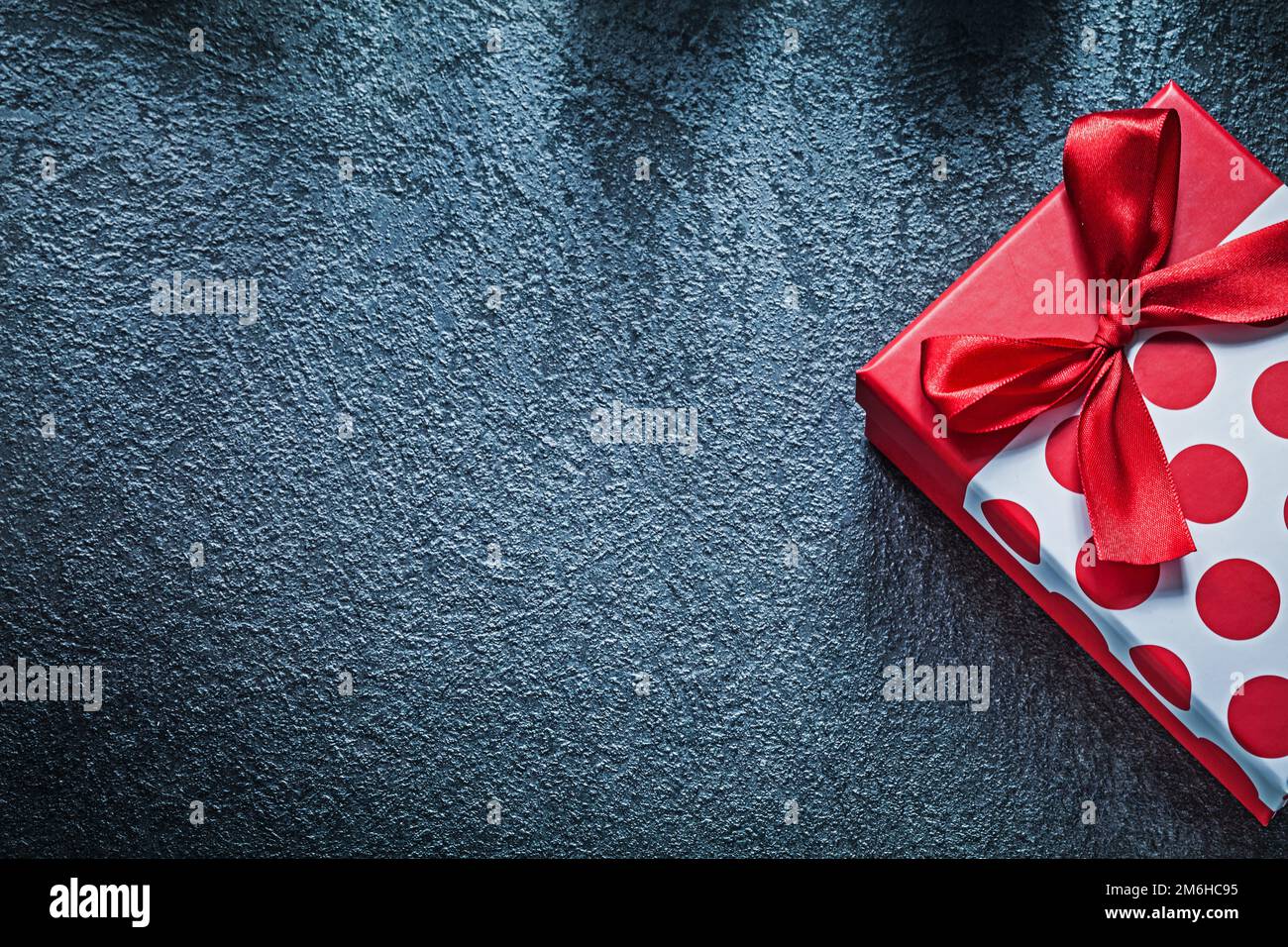 Wrapped present box with tied bow on black background holidays concept ...