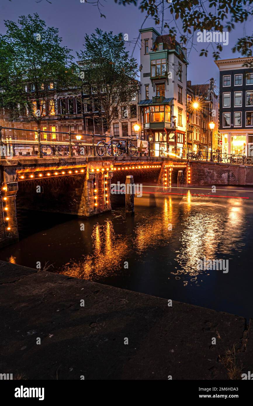 Illuminated bridge over the canals at night, Amsterdam, Netherlands ...