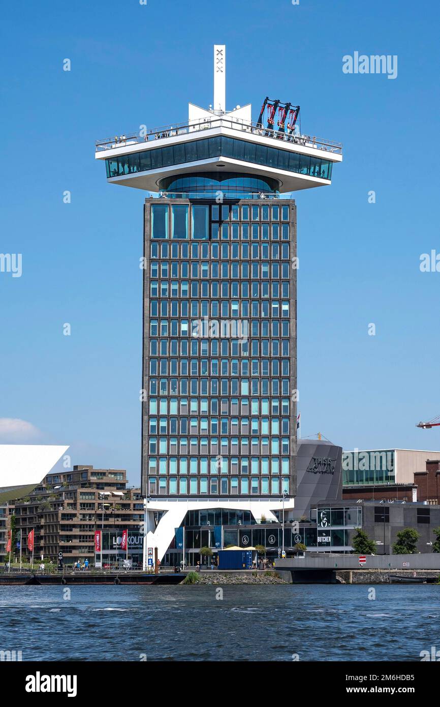 High-rise building with a swing on the roof by the city canals ...