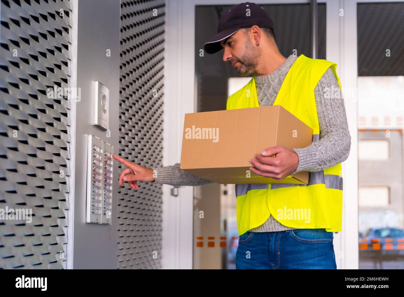 A young delivery man in a protective uniform delivering the online ...