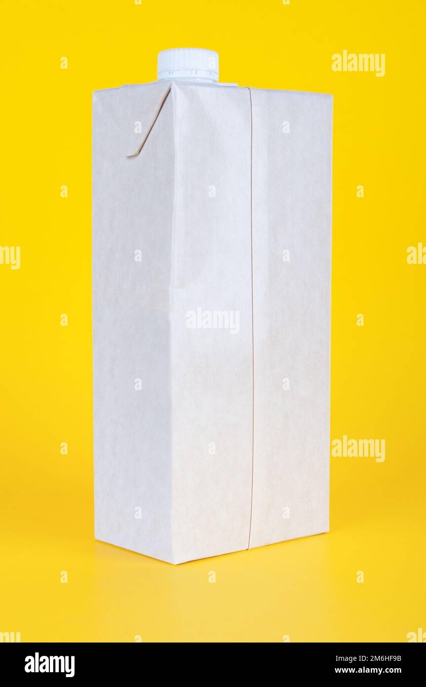 Milk carton box close up on a yellow background Stock Photo - Alamy