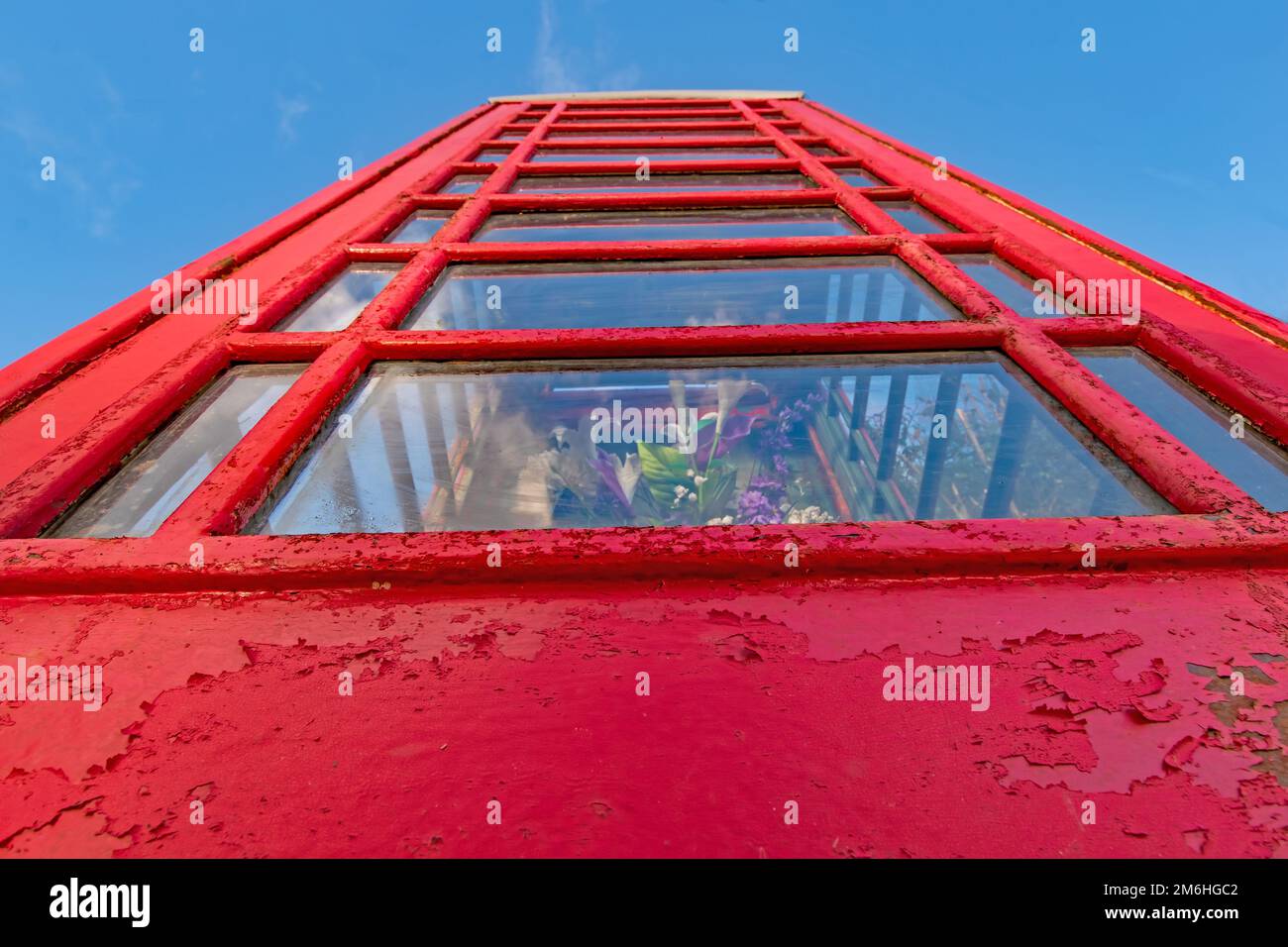 A ground level view looking up at a British Red Telephone box with ...