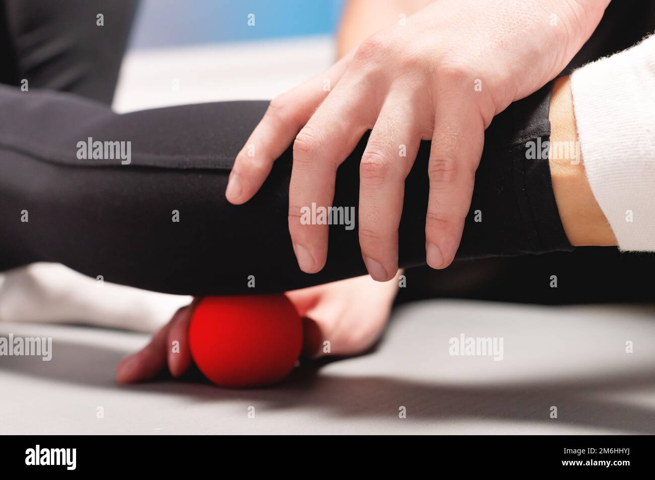 Close-up of a male massage therapist showing a client how to use and ...