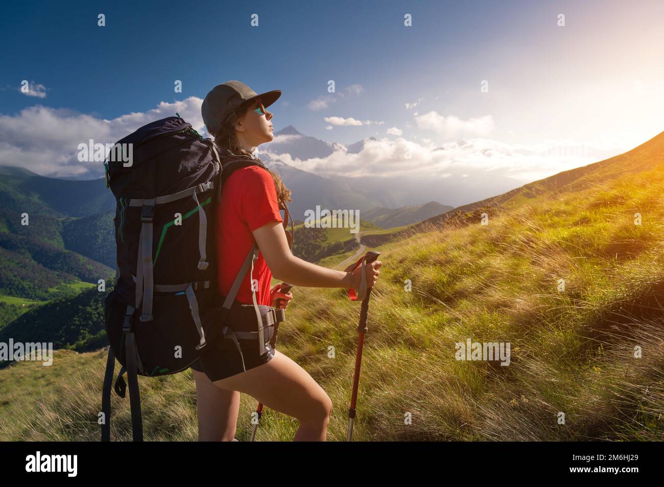 Woman tourist young caucasian walking uphill on a sunny day under ...