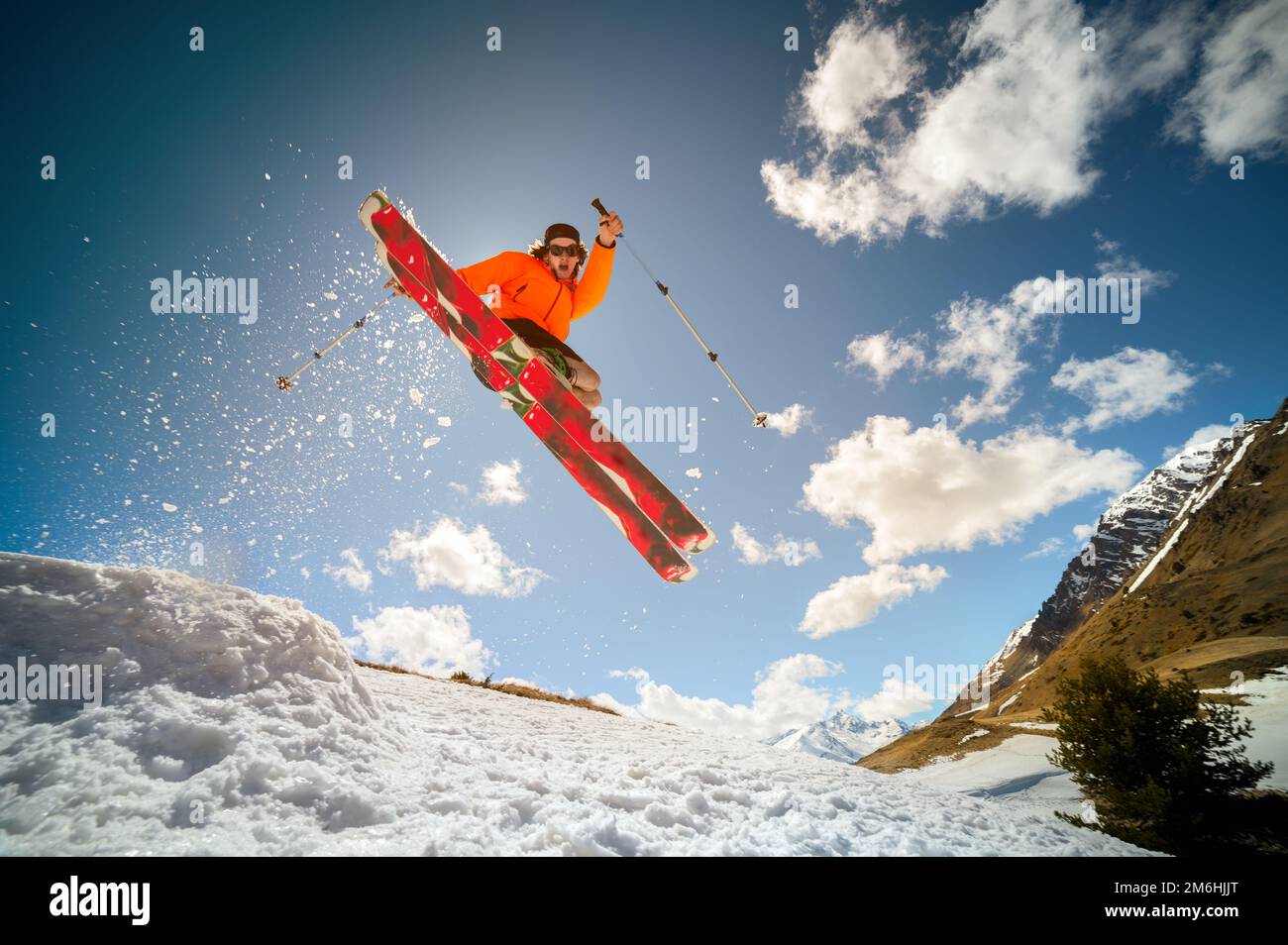 Fly young caucasian man jumping from a springboard on skis Stock Photo ...