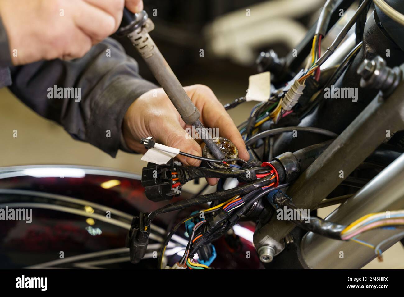 An electrician is soldering electrical wires to electrical equipment in ...