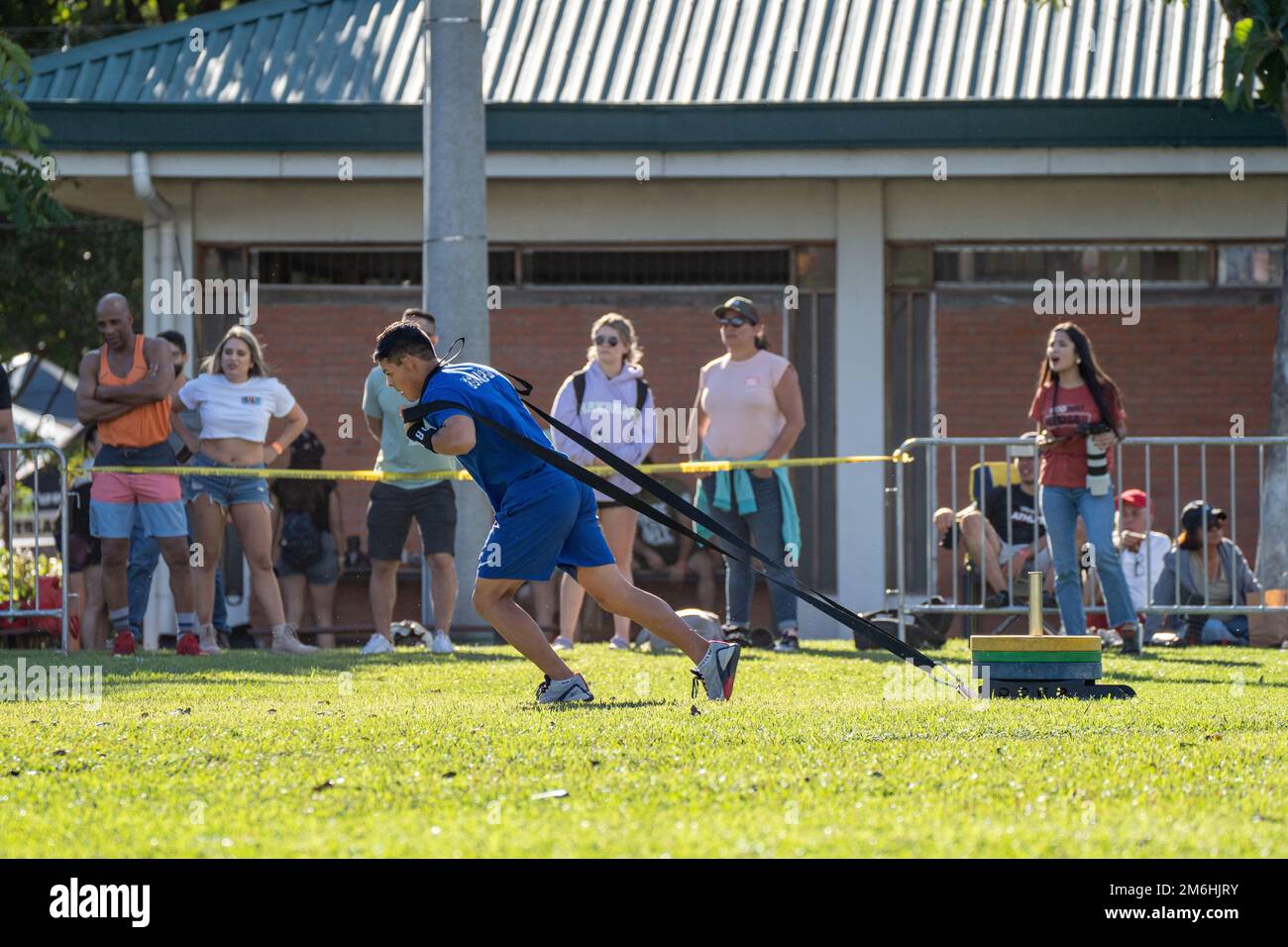 A strong athlete pulling weights with body at outdoor fitness and ...