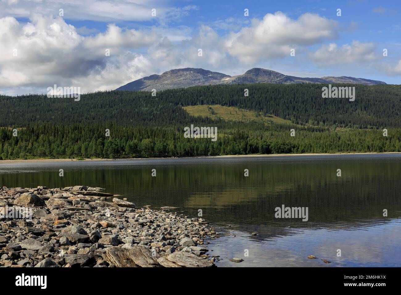 A lake surrounded by mountains against a blue cloudy sky in Are, Sweden ...