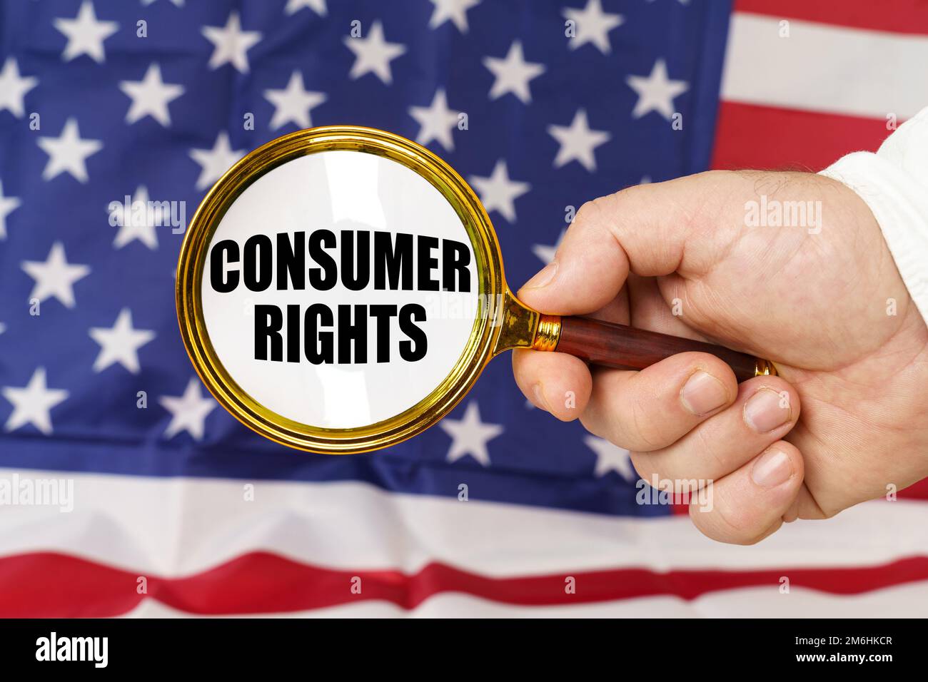 In front of the American flag, a man holds a magnifying glass in his ...