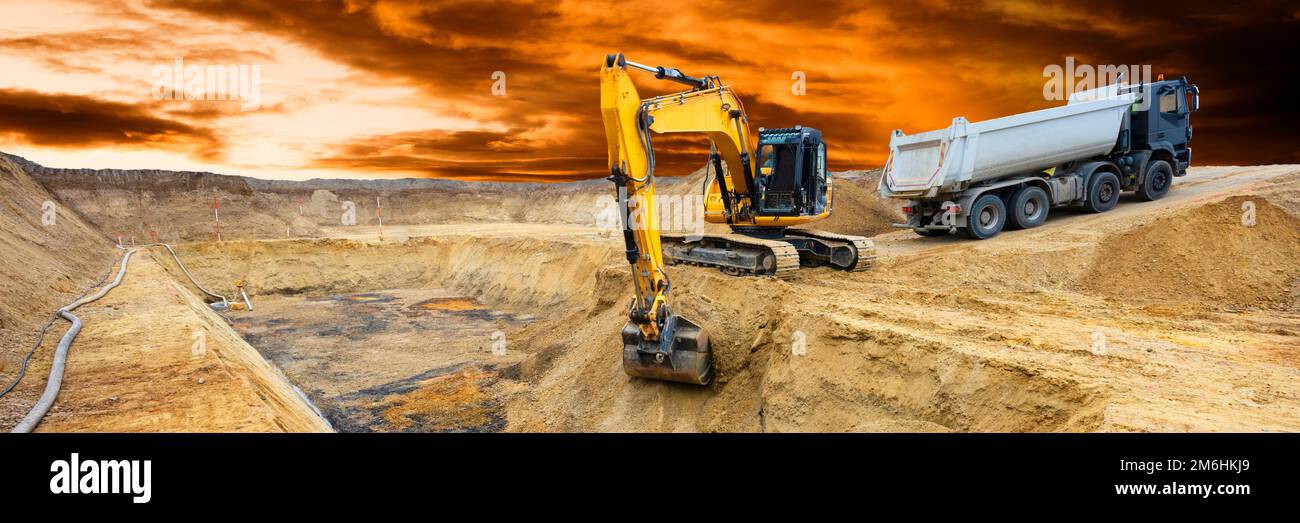 Excavator on construction site and truck at work Stock Photo - Alamy