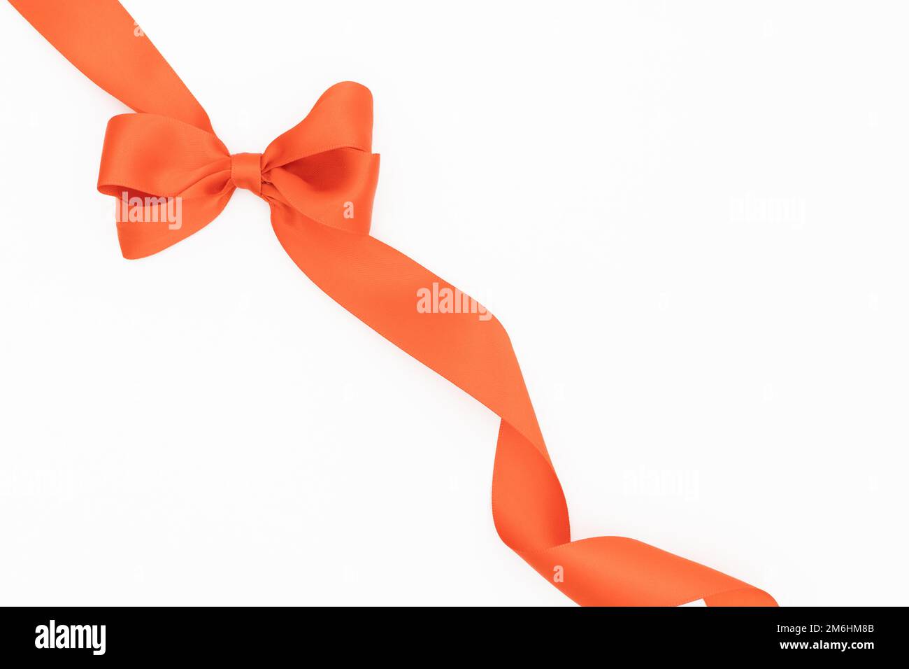 Satin ribbon bow for gift pack in orange color, isolated on white ...