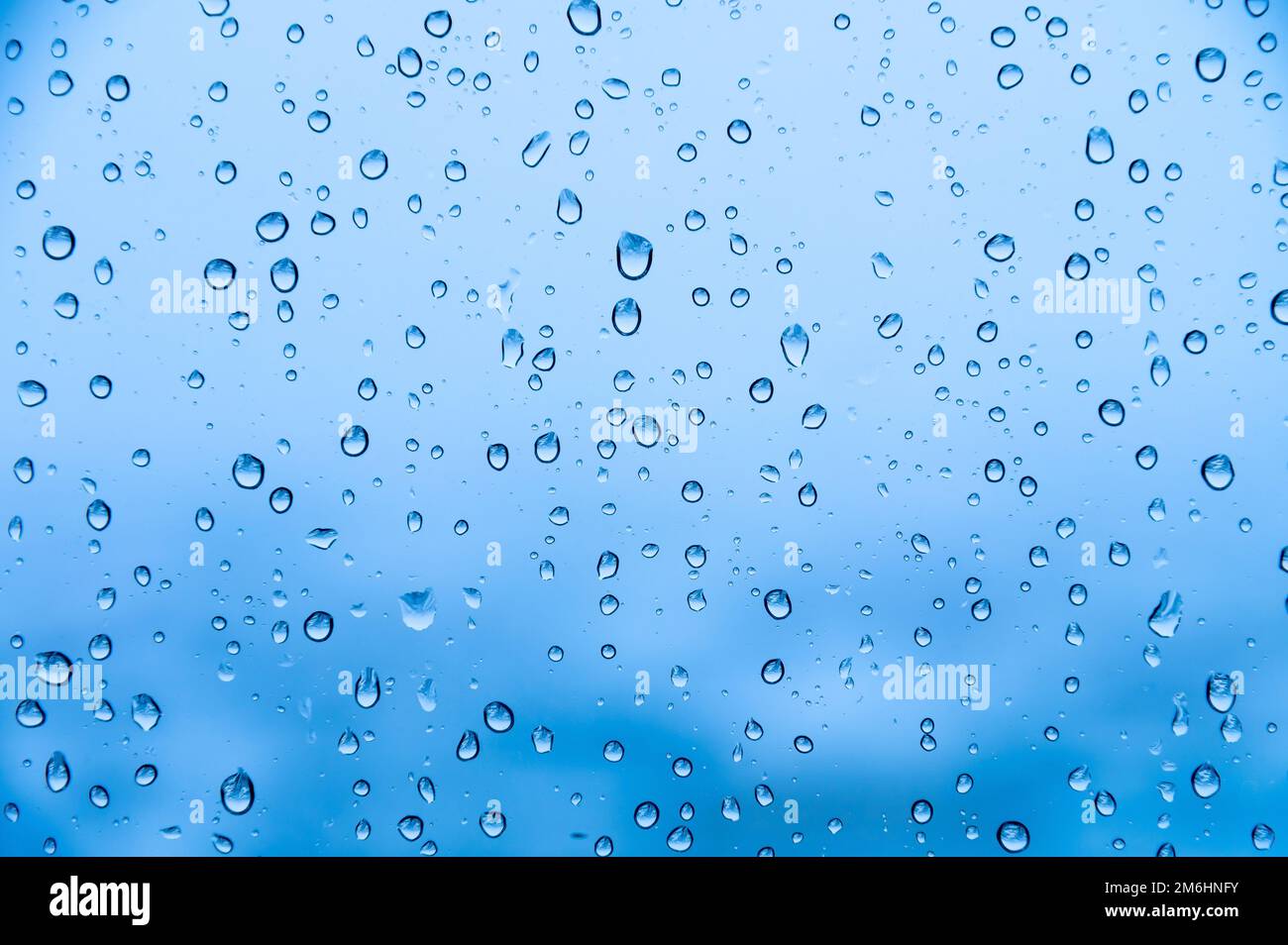 Water drops on glass natural bright blue background. Humidity ...