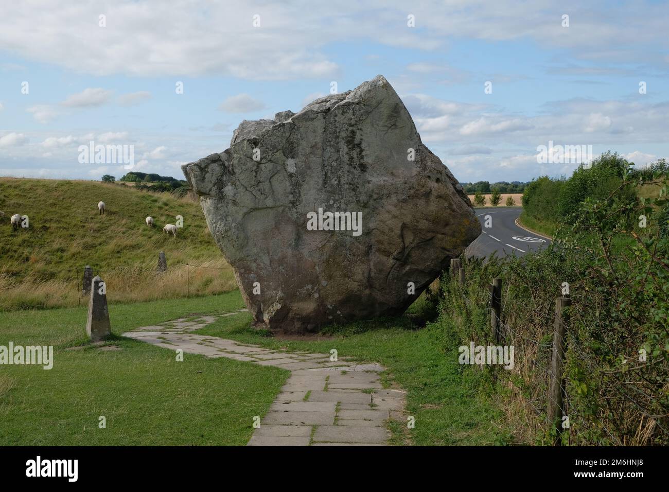 Giant square rock in a meadow with sheep Stock Photo - Alamy