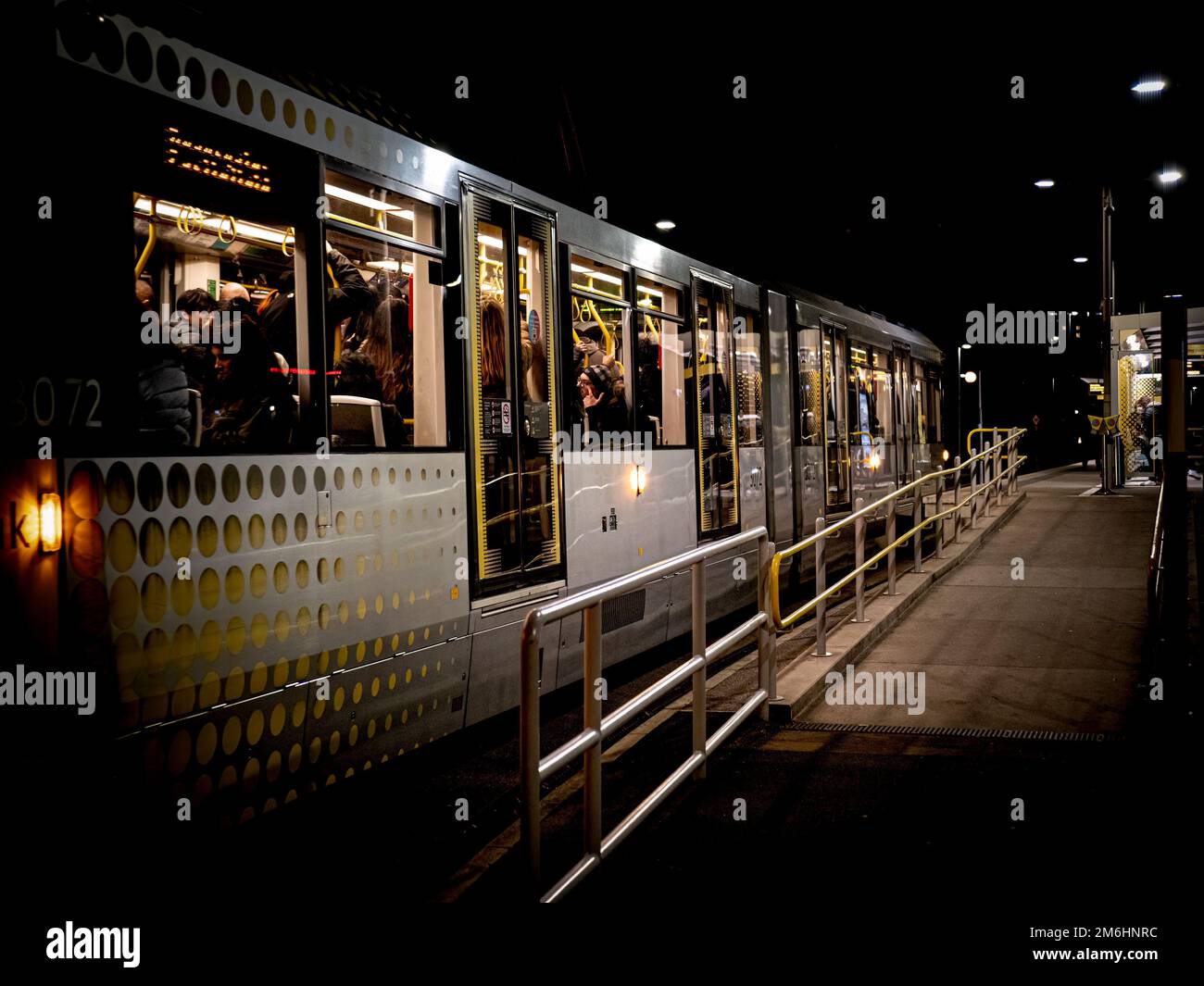 An full electric tram at station during a nighttime Stock Photo - Alamy