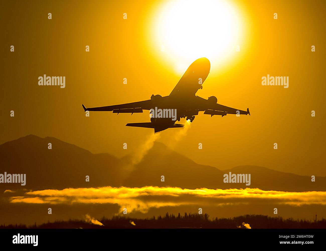 Takeoff of a passenger plane on the background of a sunset Stock Photo ...