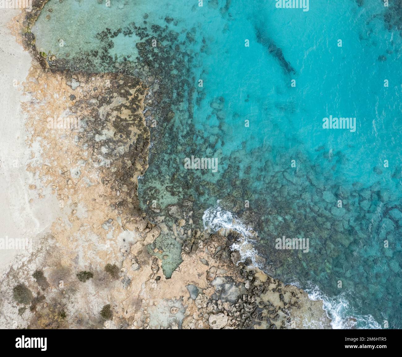 Drone aerial of rocky sea coast with transparent turquoise water ...