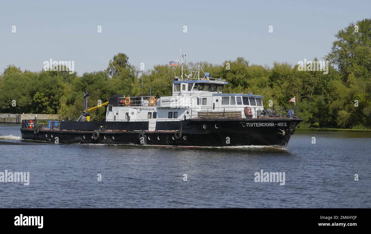 MOSCOW , RUSSIA, June 10, 2019: Old tug pushes a barge down a work on ...