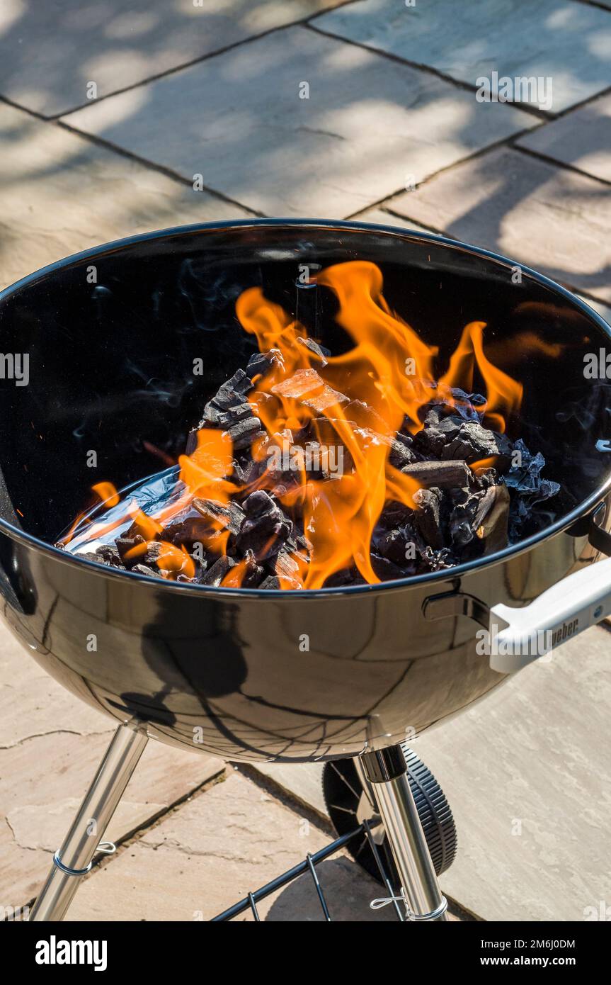 round BBQ with lit charcoal wood with flames Stock Photo - Alamy