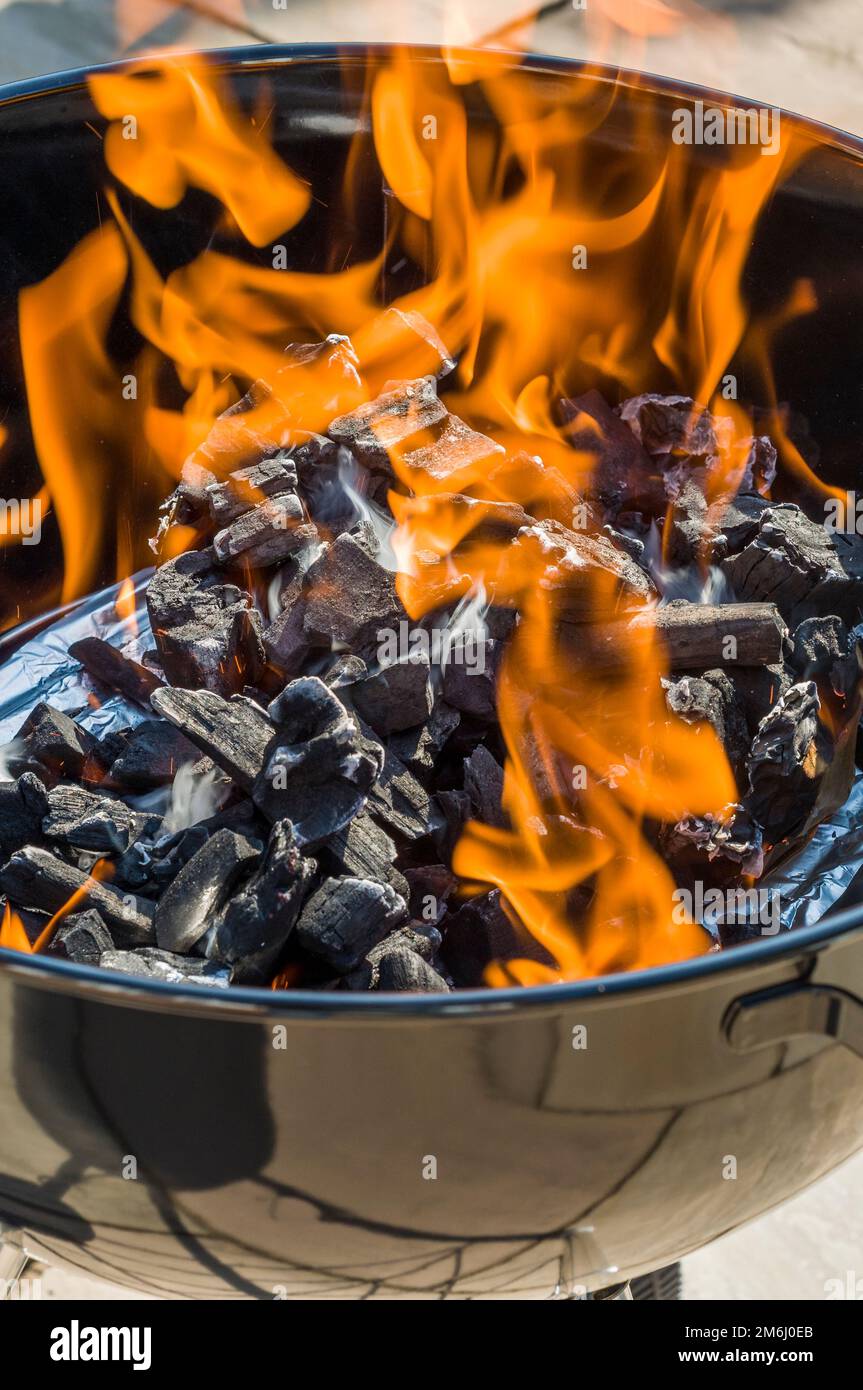 round BBQ with lit charcoal wood with flames Stock Photo - Alamy