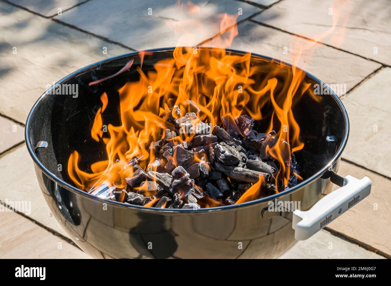 round BBQ with lit charcoal wood with flames Stock Photo - Alamy