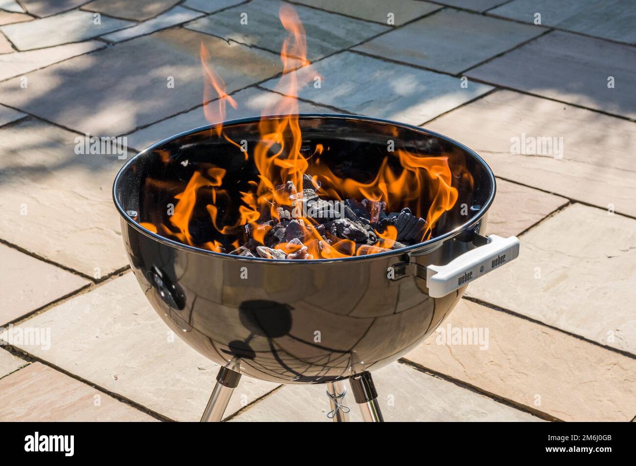 round BBQ with lit charcoal wood with flames Stock Photo - Alamy