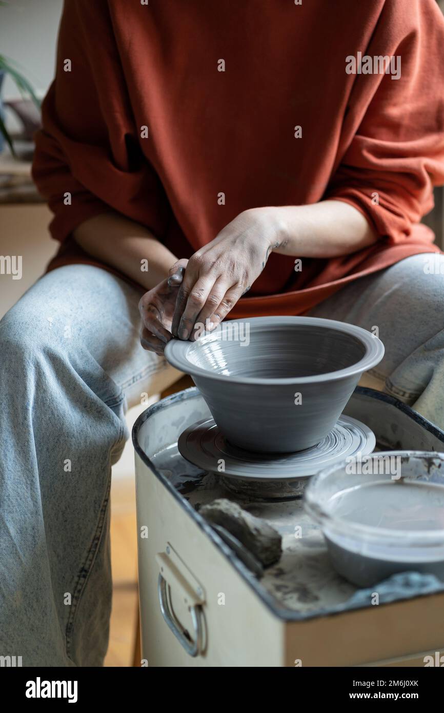 Ceramic master creating handmade stoneware on wheel in studio, forming ...