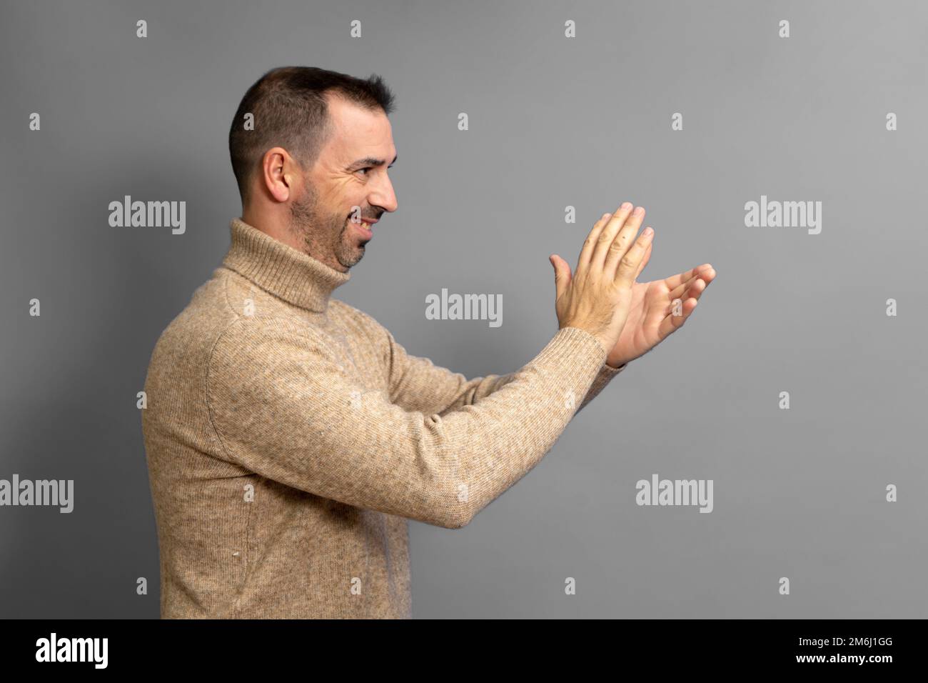 Bearded hispanic man in profile wearing brown turtleneck feeling happy ...