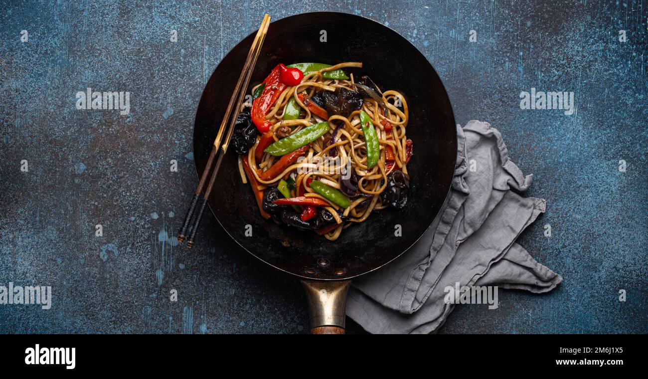 Asian stir fry noodles with vegetables in black wok pan Stock Photo - Alamy
