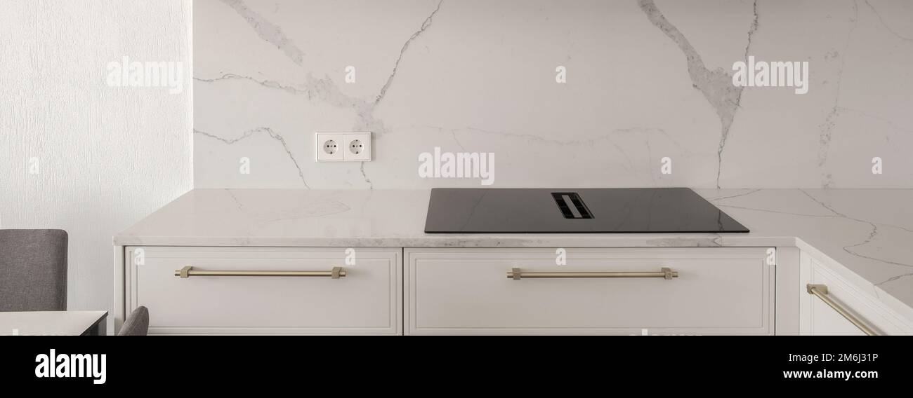 Warm white kitchen interior design, electric hob with integrated ...