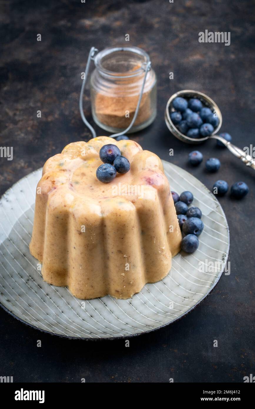 Traditional English plum pudding as closeup with fruits on a dessert ...