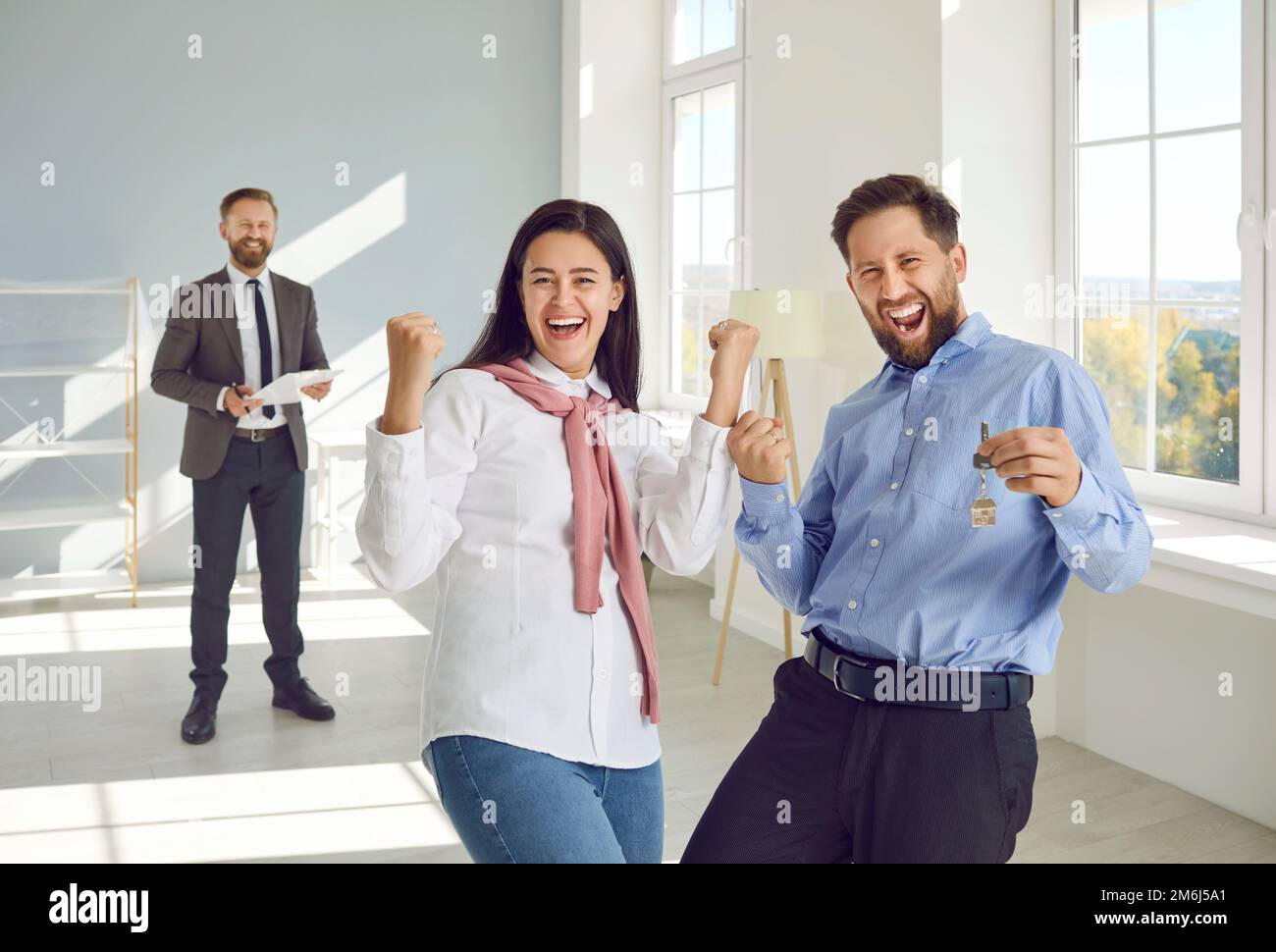 Happy overjoyed couple family with yes gesture and keys from their new ...