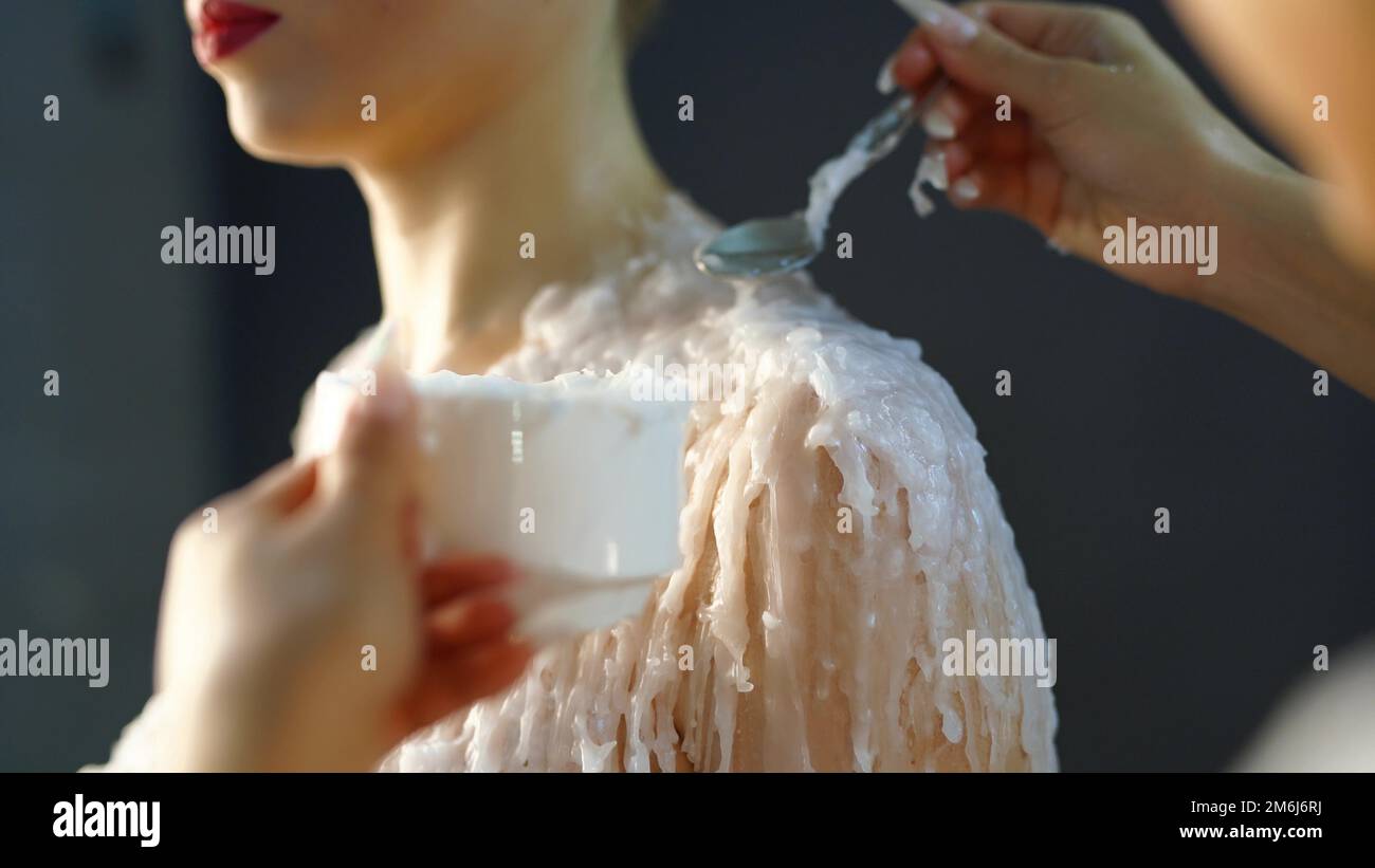 Crop artist pouring liquid wax on model Stock Photo - Alamy