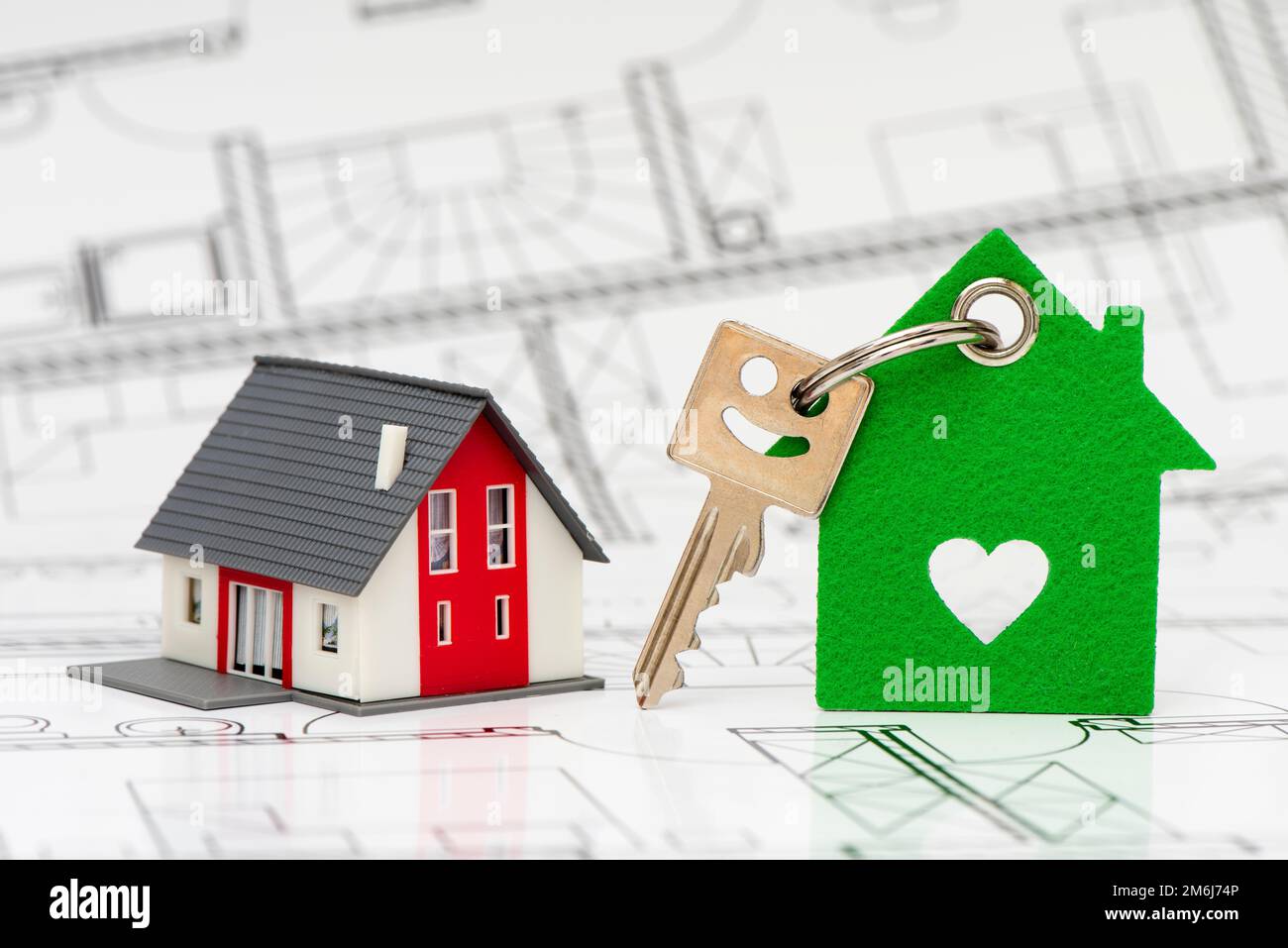 Model home with key standing on construction plan Stock Photo - Alamy