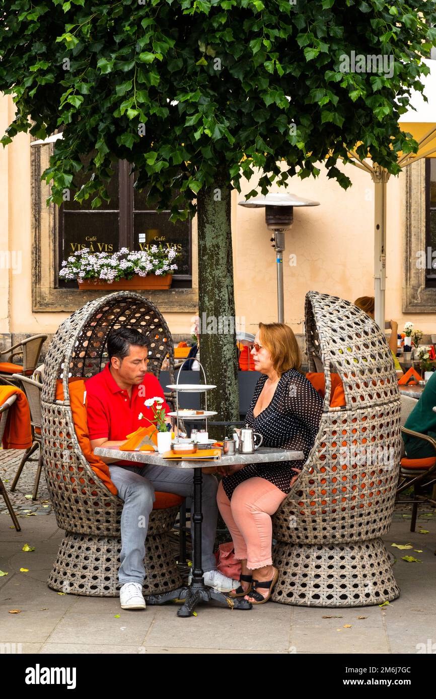 People enjoying quiet drinks and lunch seated outdoors in wicker basket ...