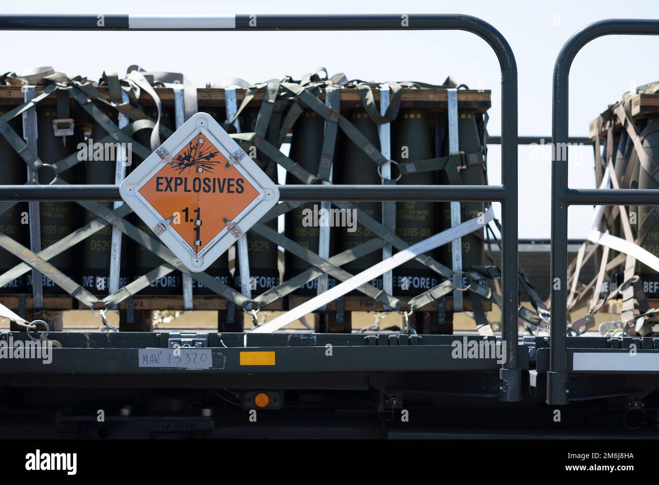 Pallets holding munitions are transported off an aircraft cargo loader ...
