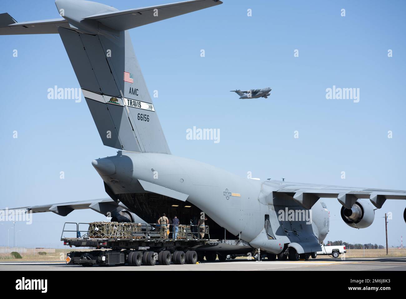 U.S. Airmen load pallets holding munitions into a C-17 Globemaster III ...