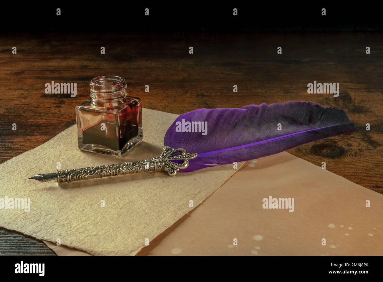 Feather quill pen with a vintage ink well and old paper Stock Photo - Alamy