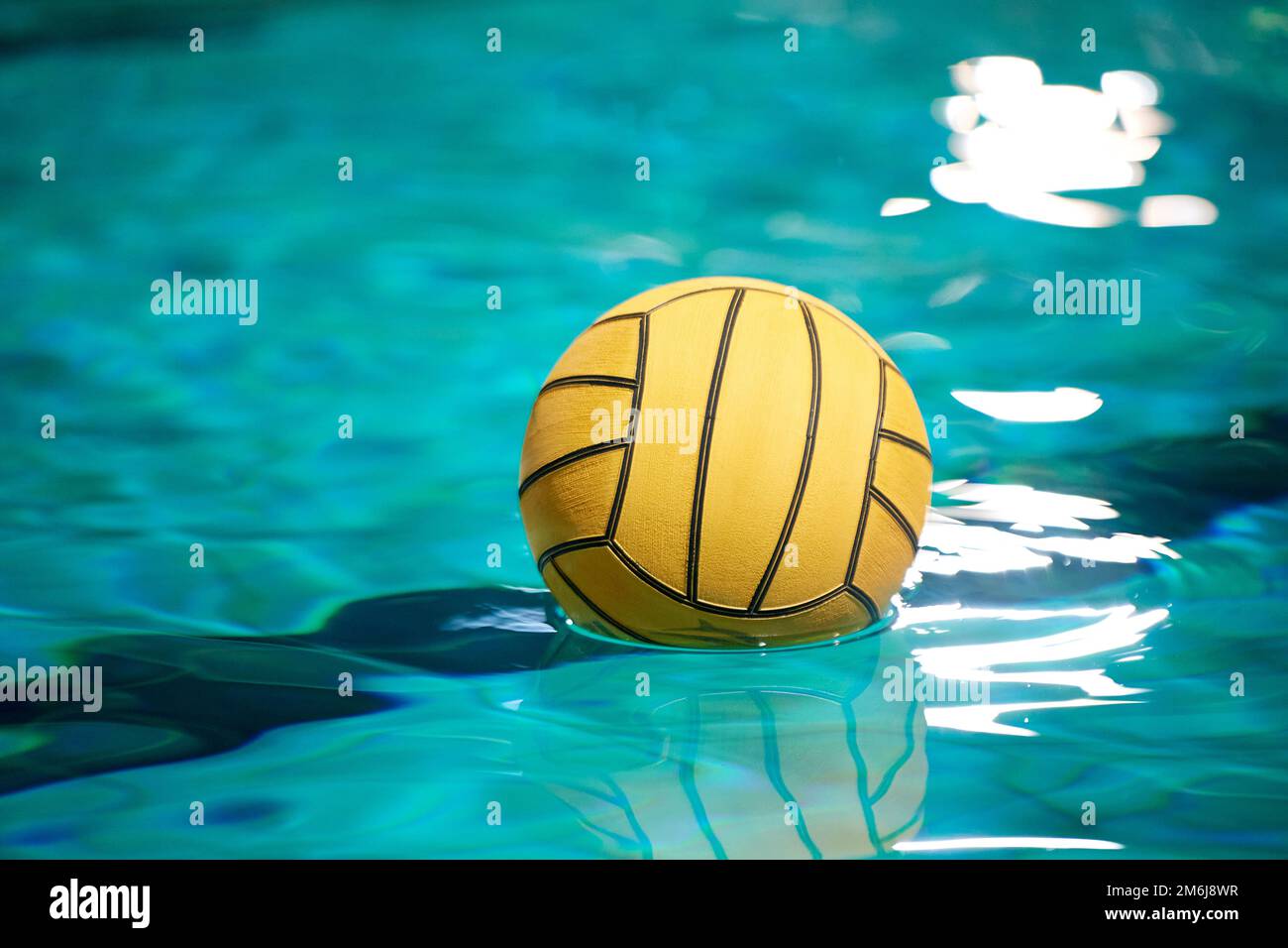 Water polo. Yellow water polo ball in a swimming pool on blue water ...